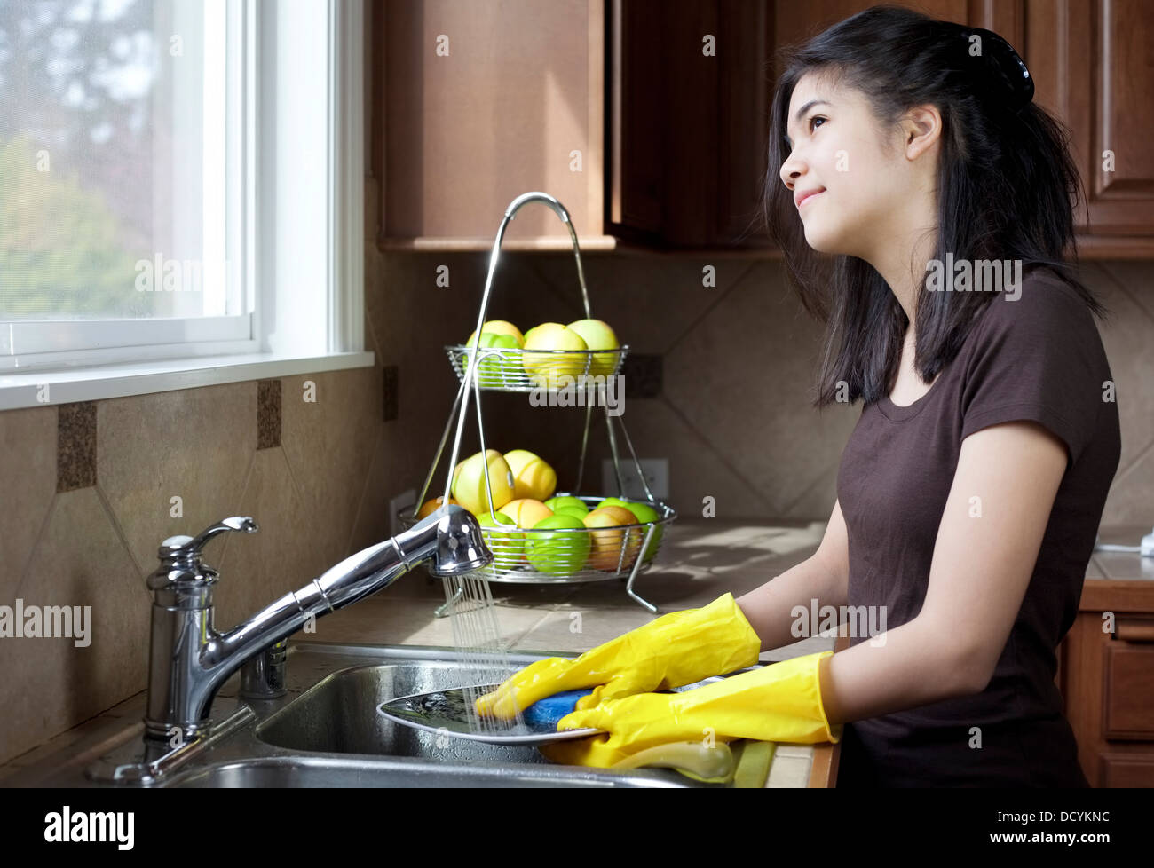Teen girl washing dishes at kitchen sink Stock Photo - Alamy