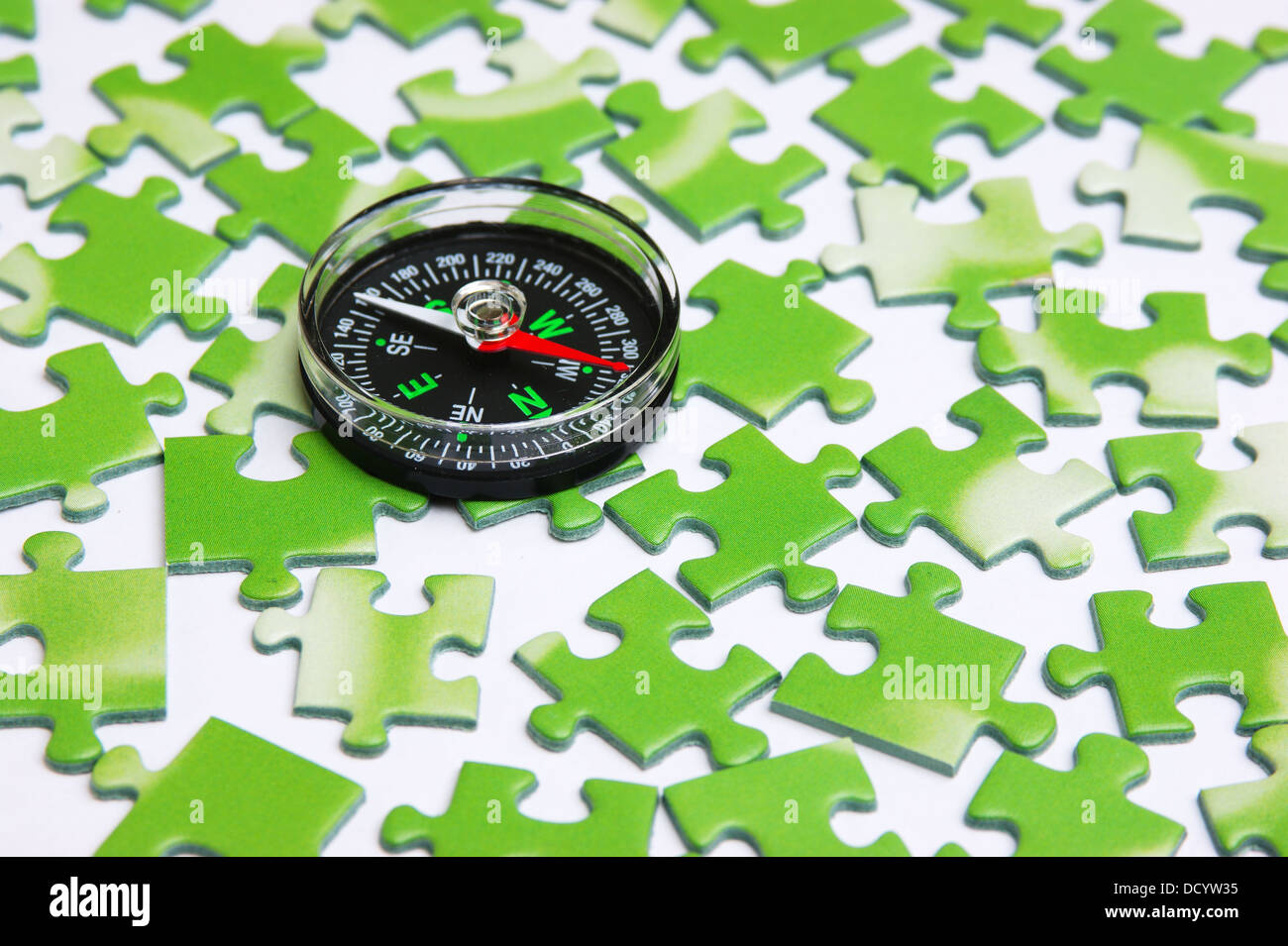 compass on the green puzzle Stock Photo - Alamy