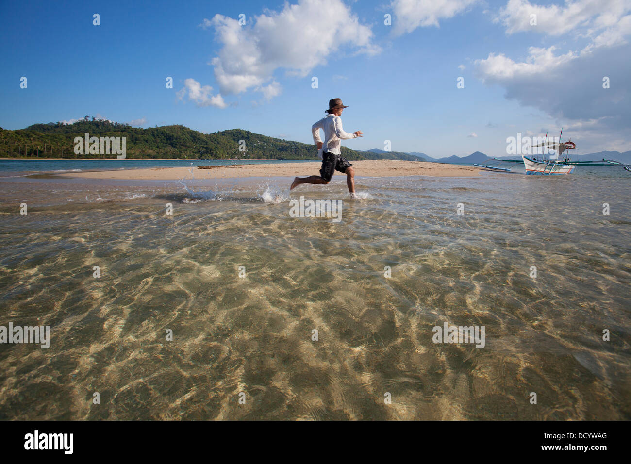 A Male Tourist Runs Through The Tropical Water At A Sandbar Island Near ...