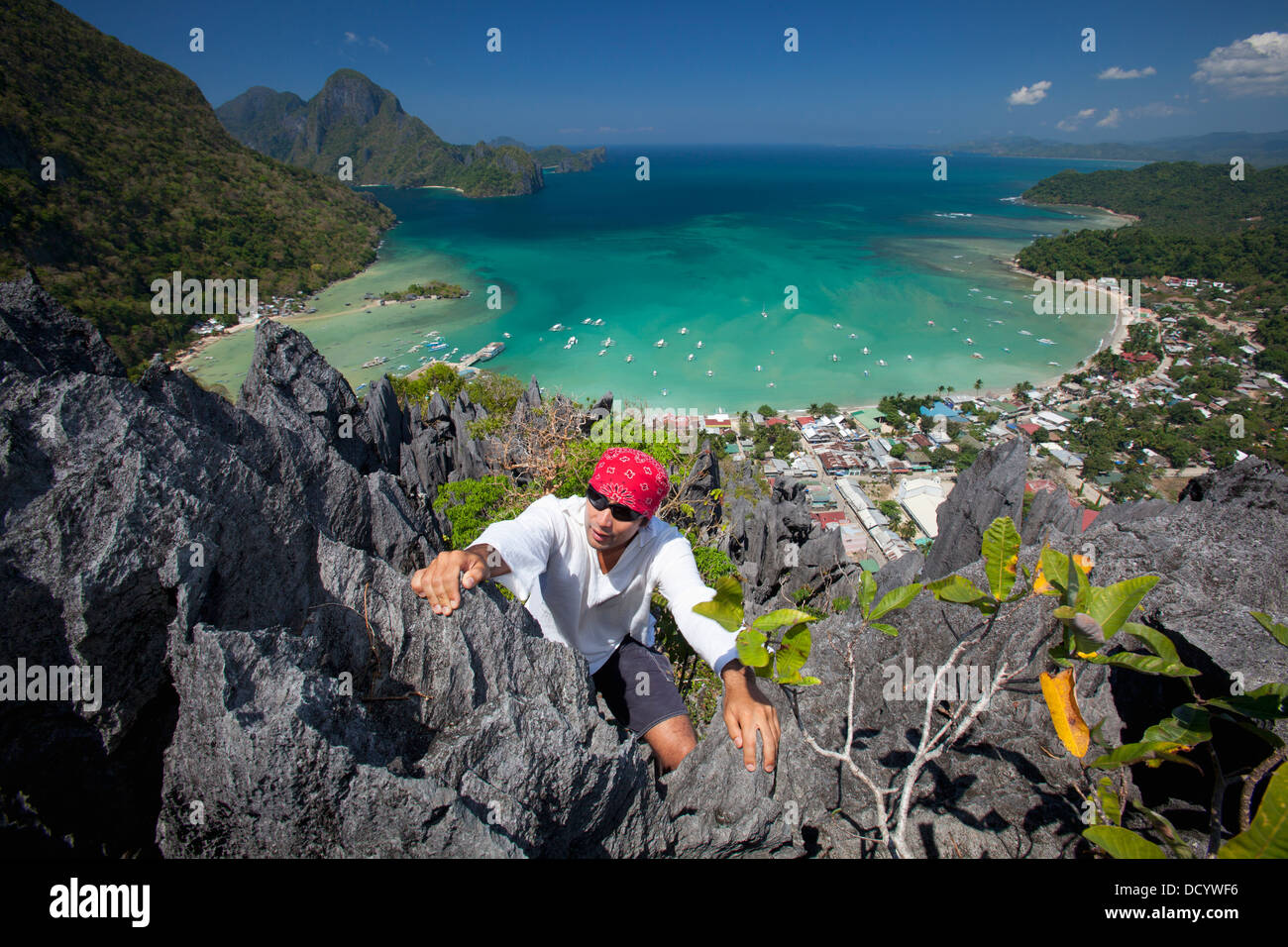 A Man Rock Climbs On Top Of Sharp Limestone Spires Overlooking The ...
