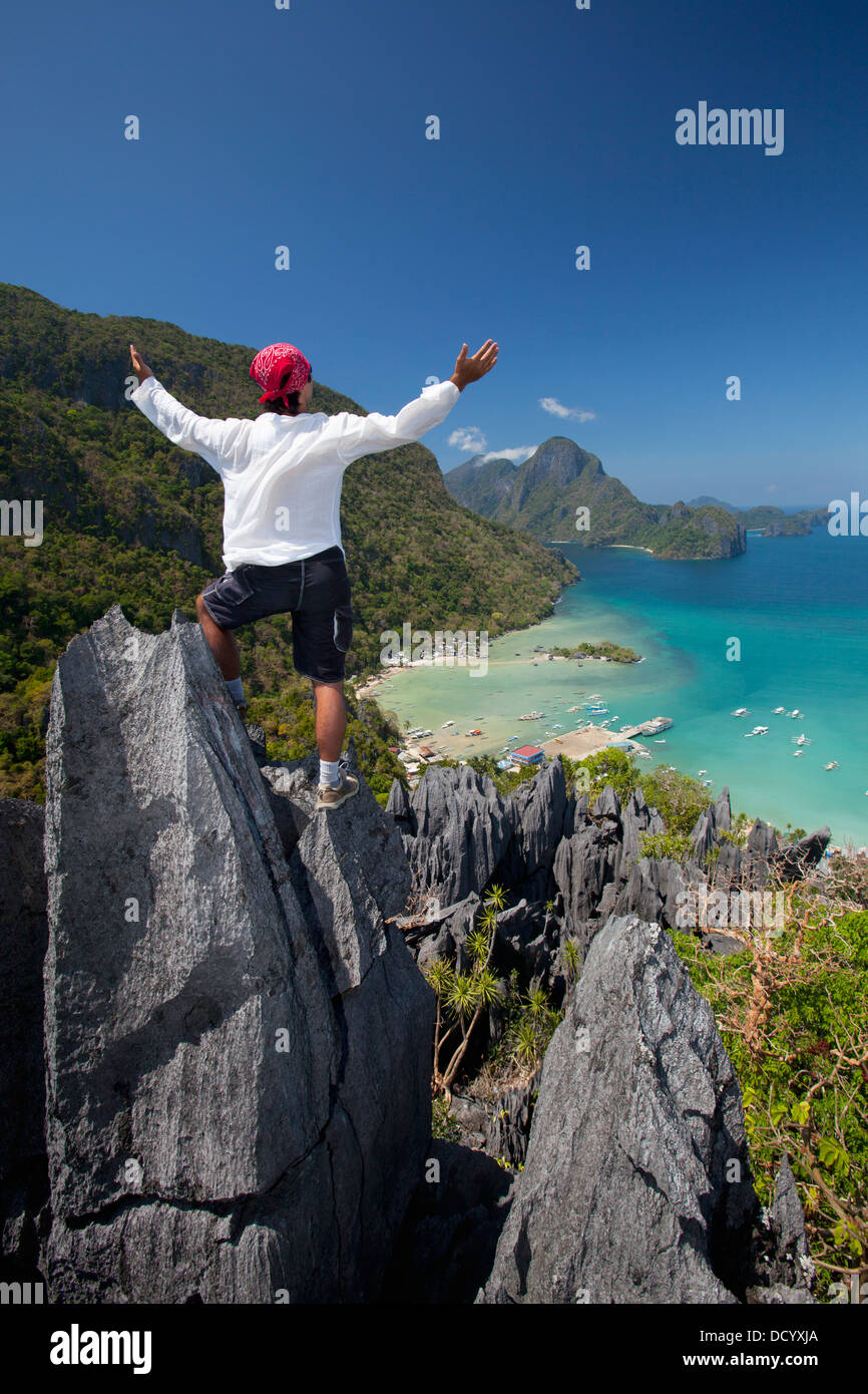 A Man Raises His Arms In Praise On Top Of Sharp Limestone Spires ...