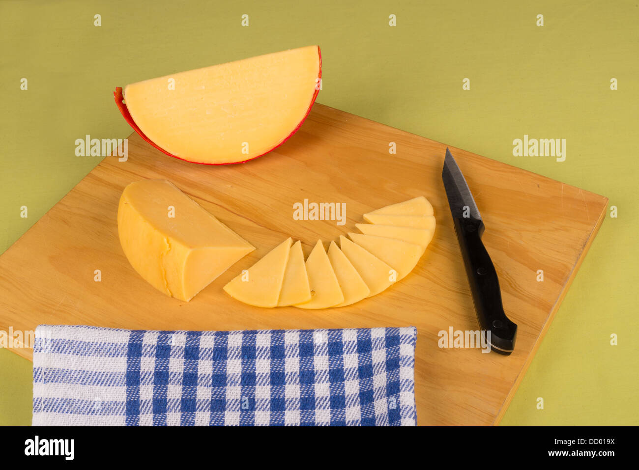 Gouda cheese wedge on a chopping board Stock Photo - Alamy