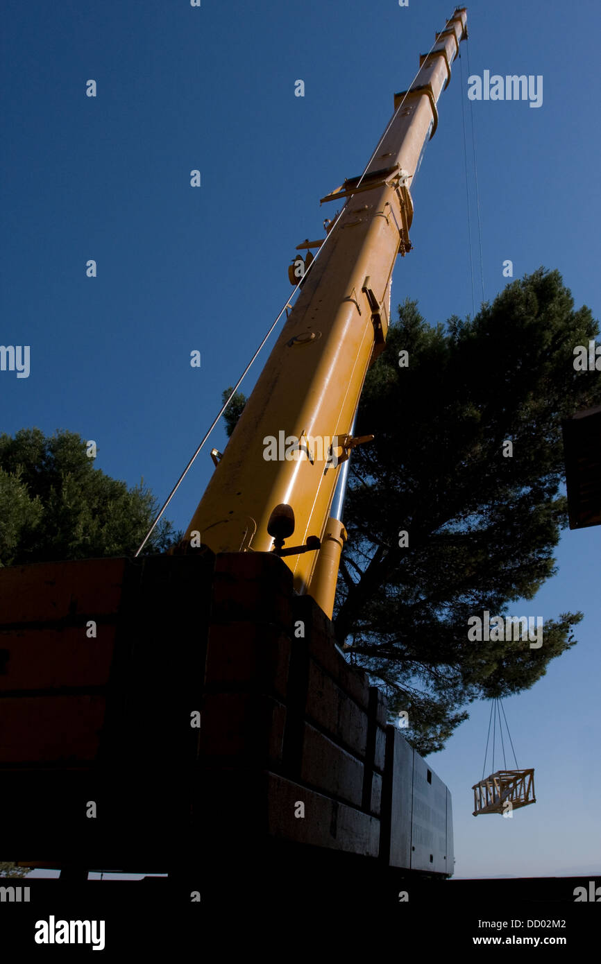 Crane tower pointing skyward, and crane part being swung in air for ...