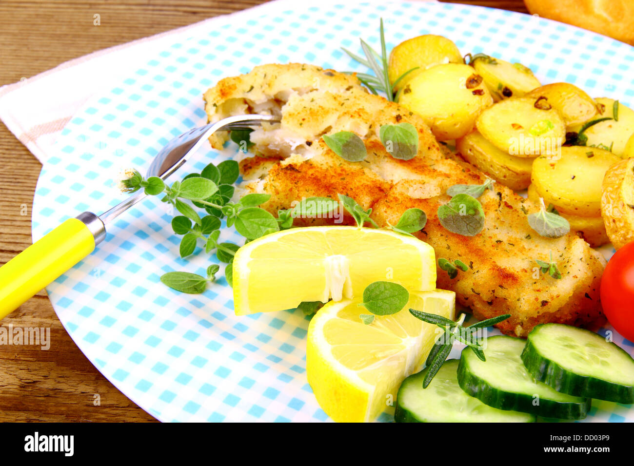Fried rosemary potatoes and fish fillet with vegetables, close up Stock ...
