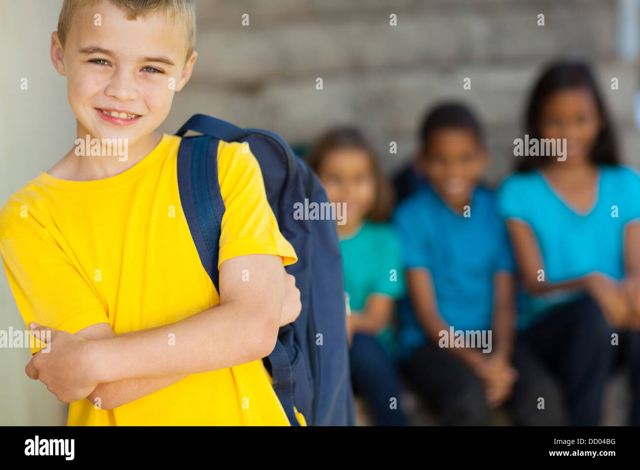 cute young primary schoolboy with arms crossed in front of classmates ...