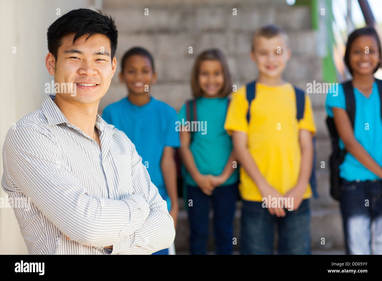 handsome male elementary educator with students on background Stock ...