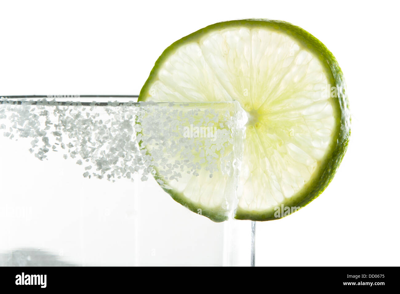 lime wheel and salt on the rim of a glass isolated on a white ...