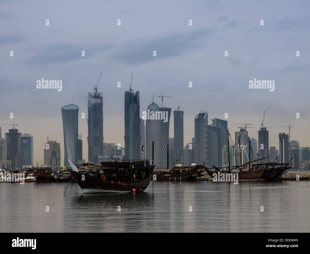 Skyline under construction in background with fishing fleet in bay in ...