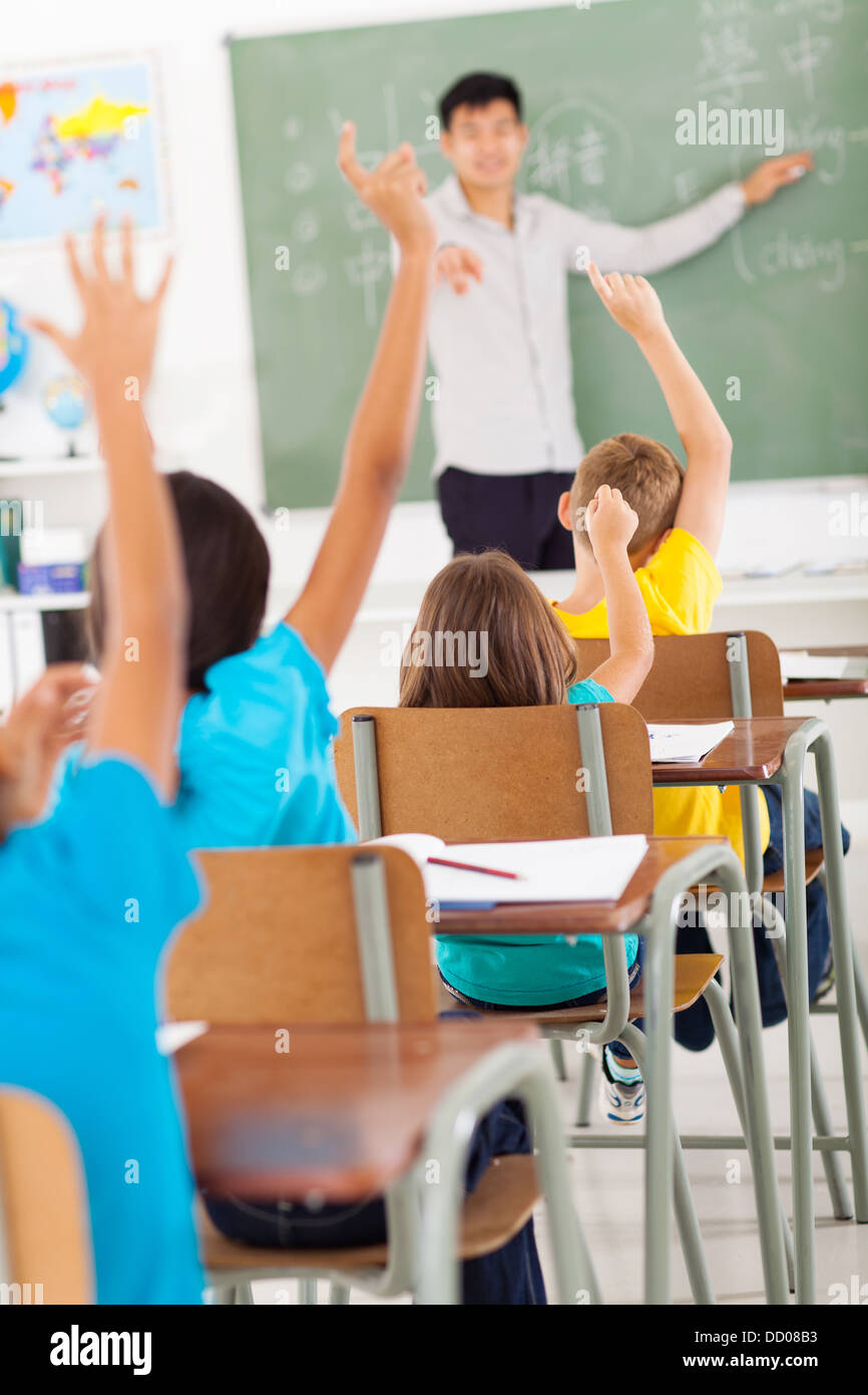 chinese language teacher in classroom pointing students who raised ...