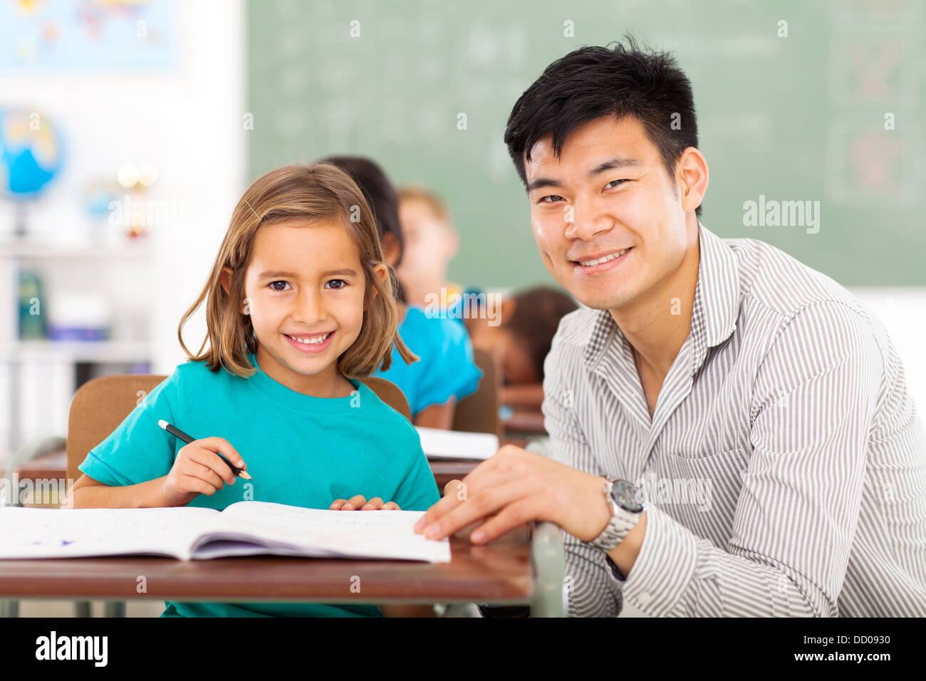 caring elementary school teacher helping student in classroom Stock ...
