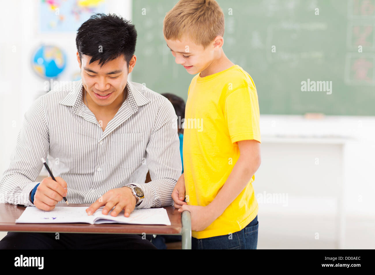 cheerful young male teacher grading school boy's work Stock Photo - Alamy