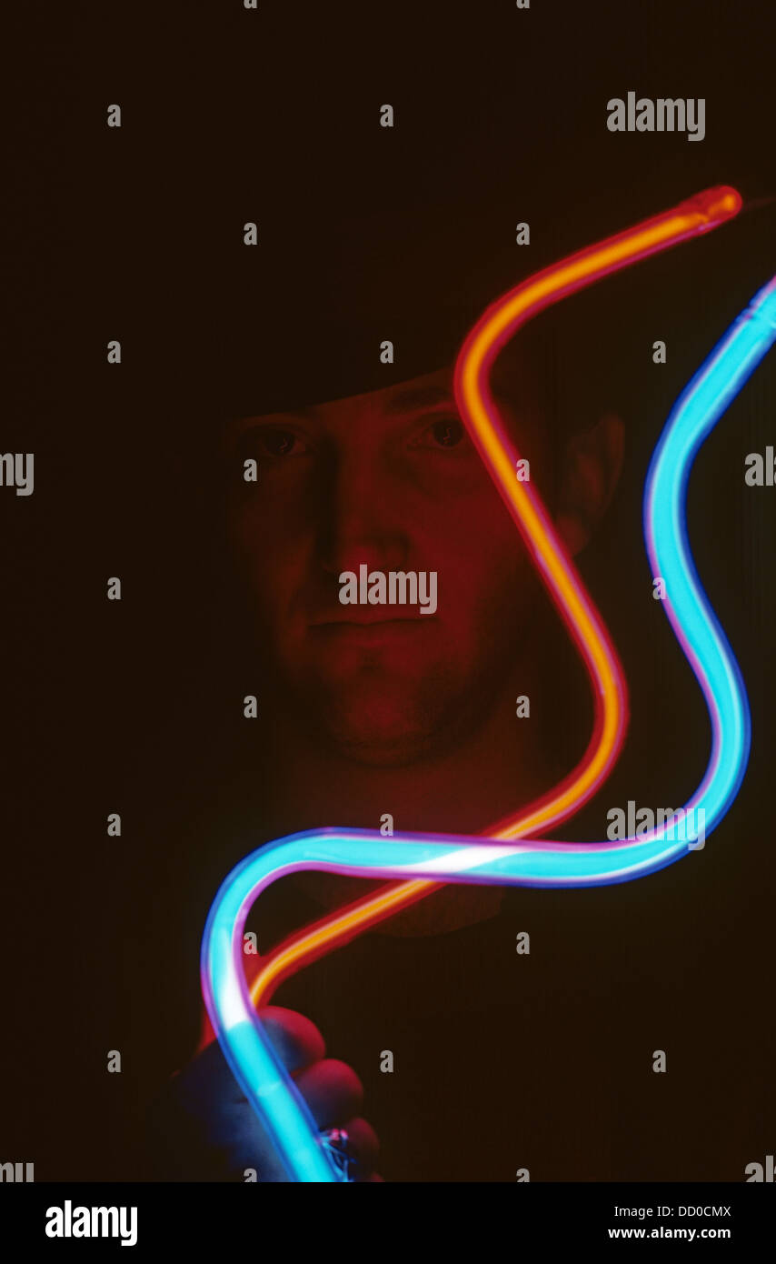 Neon Artist portrait holding neon tubes Stock Photo - Alamy