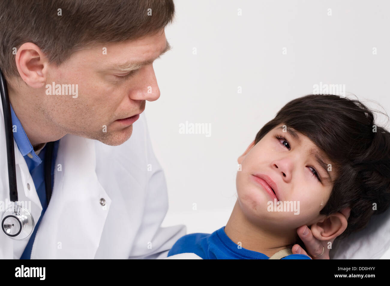 Male doctor comforting disabled toddler patient. Child is five years ...