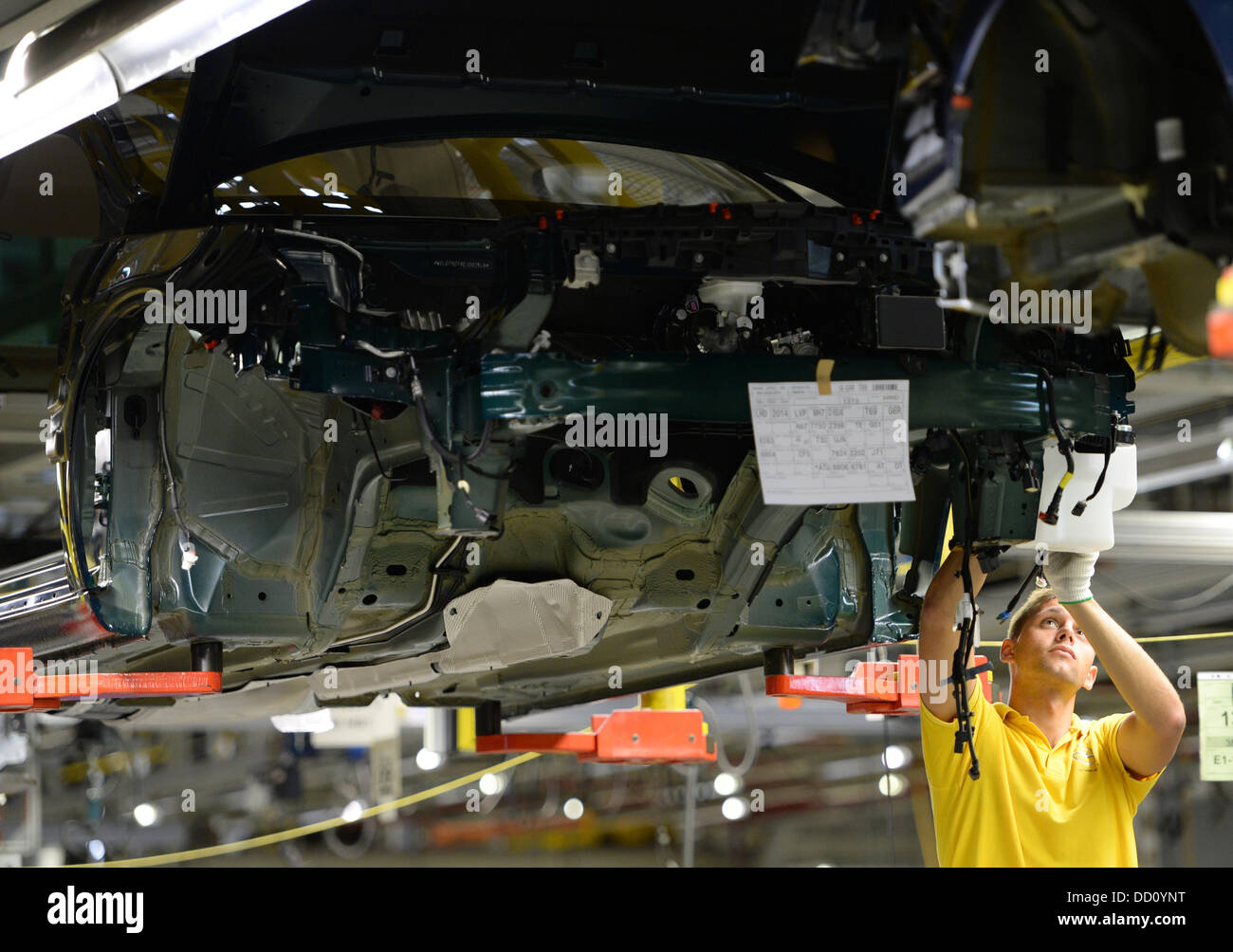 An Opel employee screws parts on different car models in the production ...