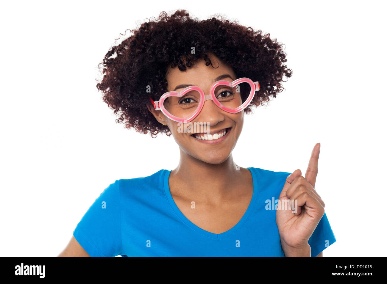 Curly haired young woman wearing heart shaped frame and pointing away ...
