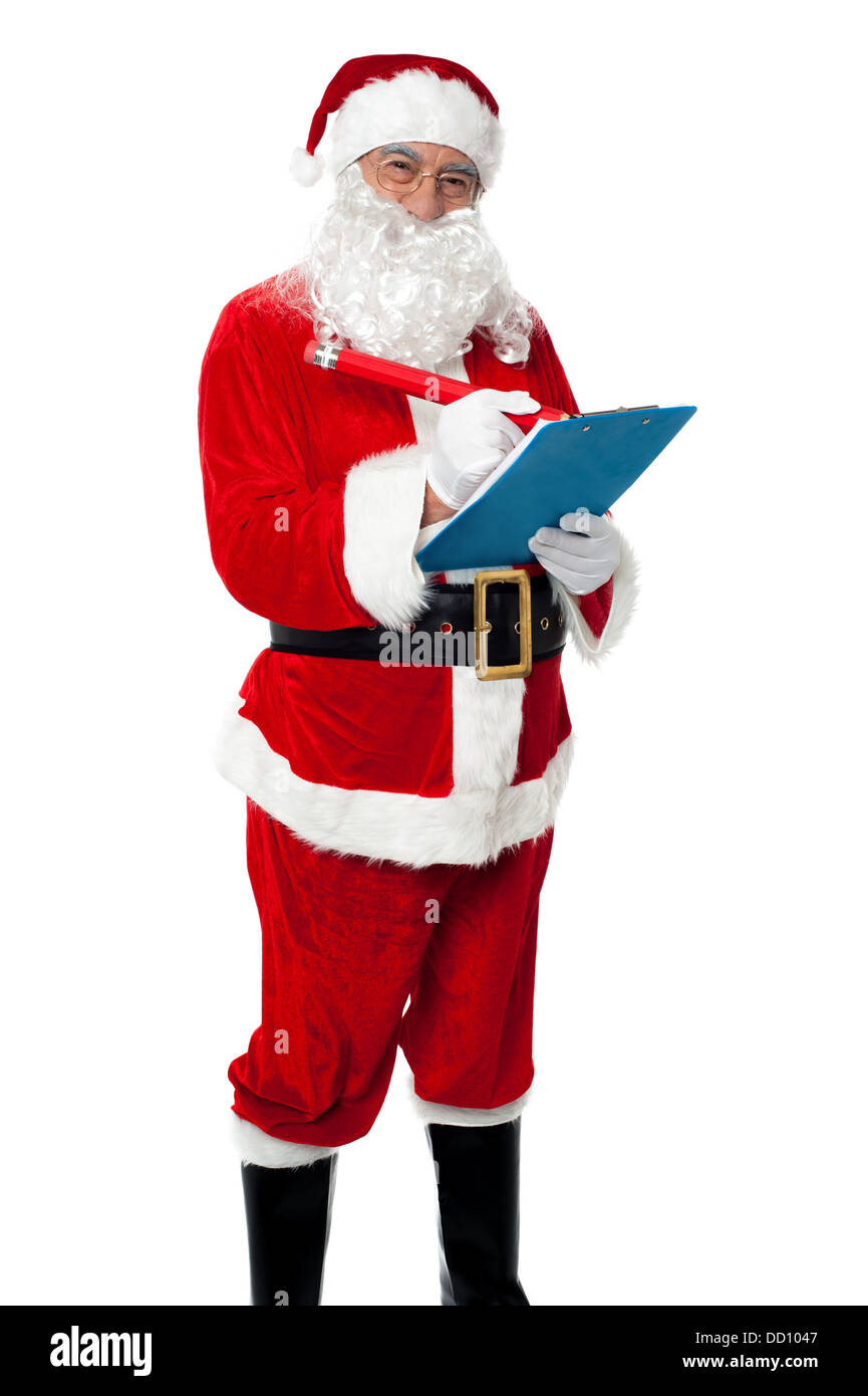 Santa Claus making list of gift recipients and smiling at the camera ...