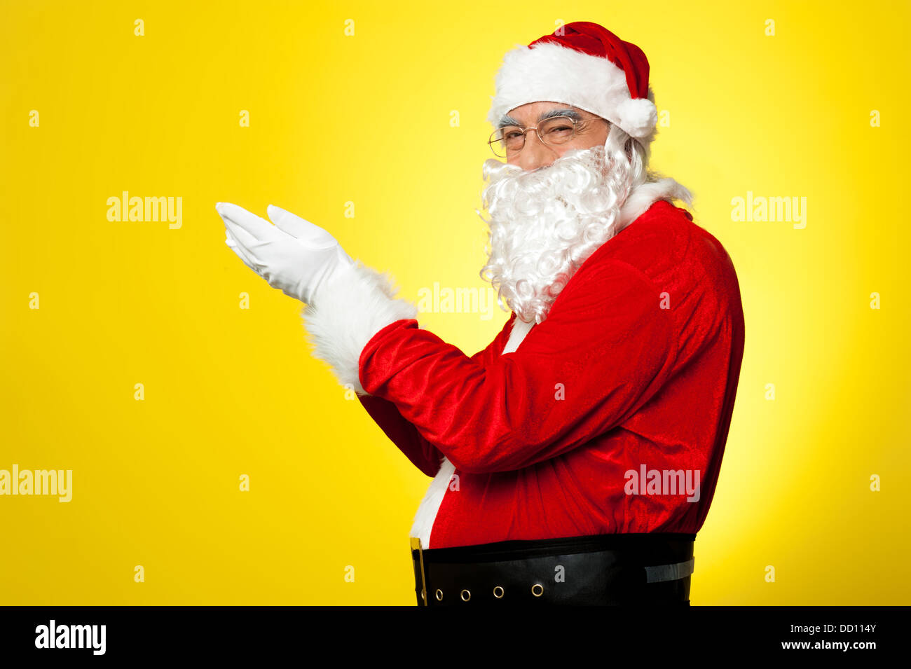 Side profile of Santa facing camera with open palms. All on yellow ...