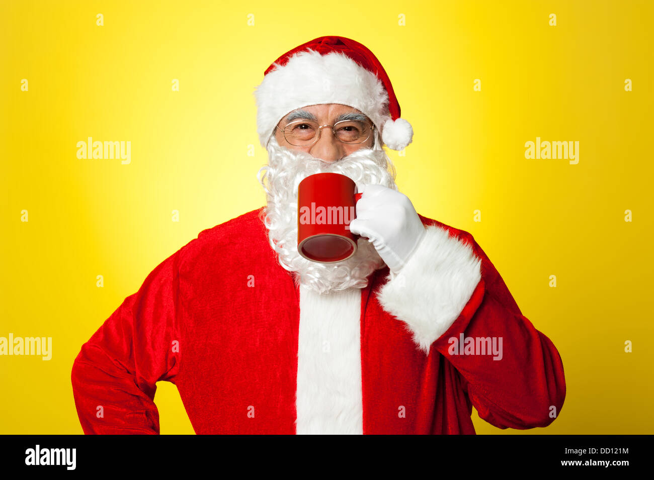 Relaxed Santa enjoying his cup of coffee. Isolated against yellow ...