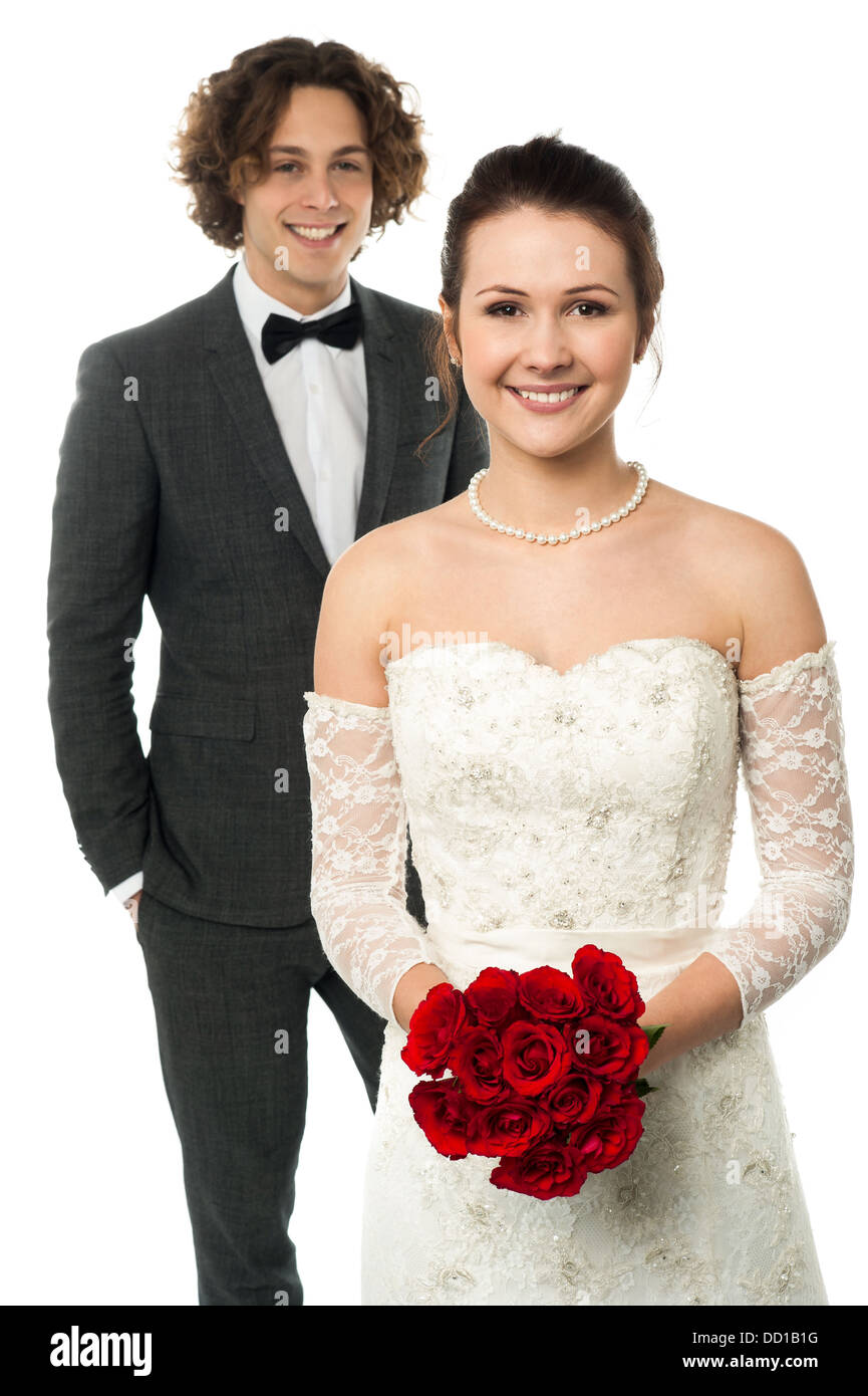 Smiling faces, studio shot of a handsome groom and lovely pretty wife ...