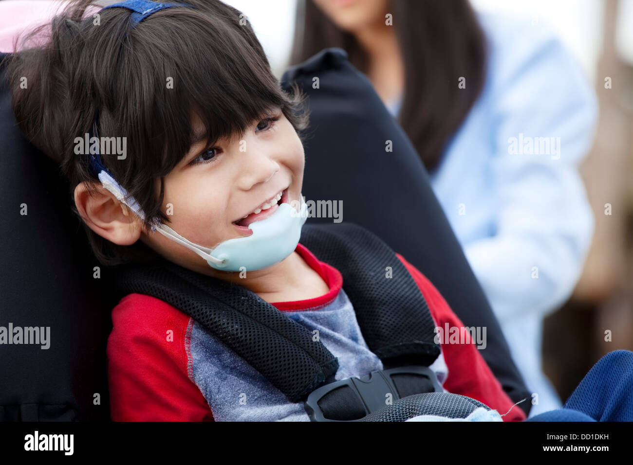 Happy five year old disabled boy in wheelchair and protective ge Stock ...