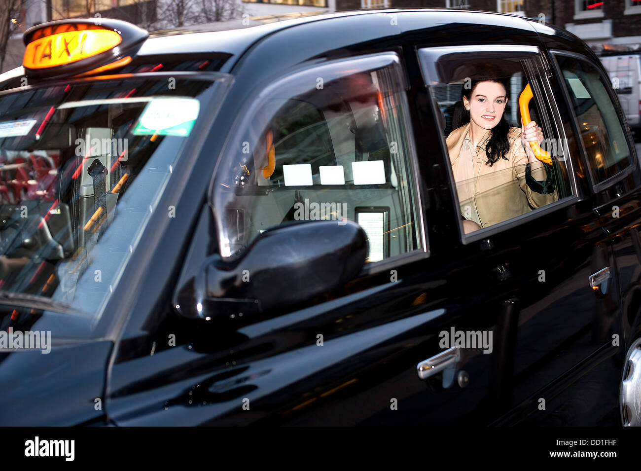 Happy female passenger inside of a taxi Stock Photo - Alamy