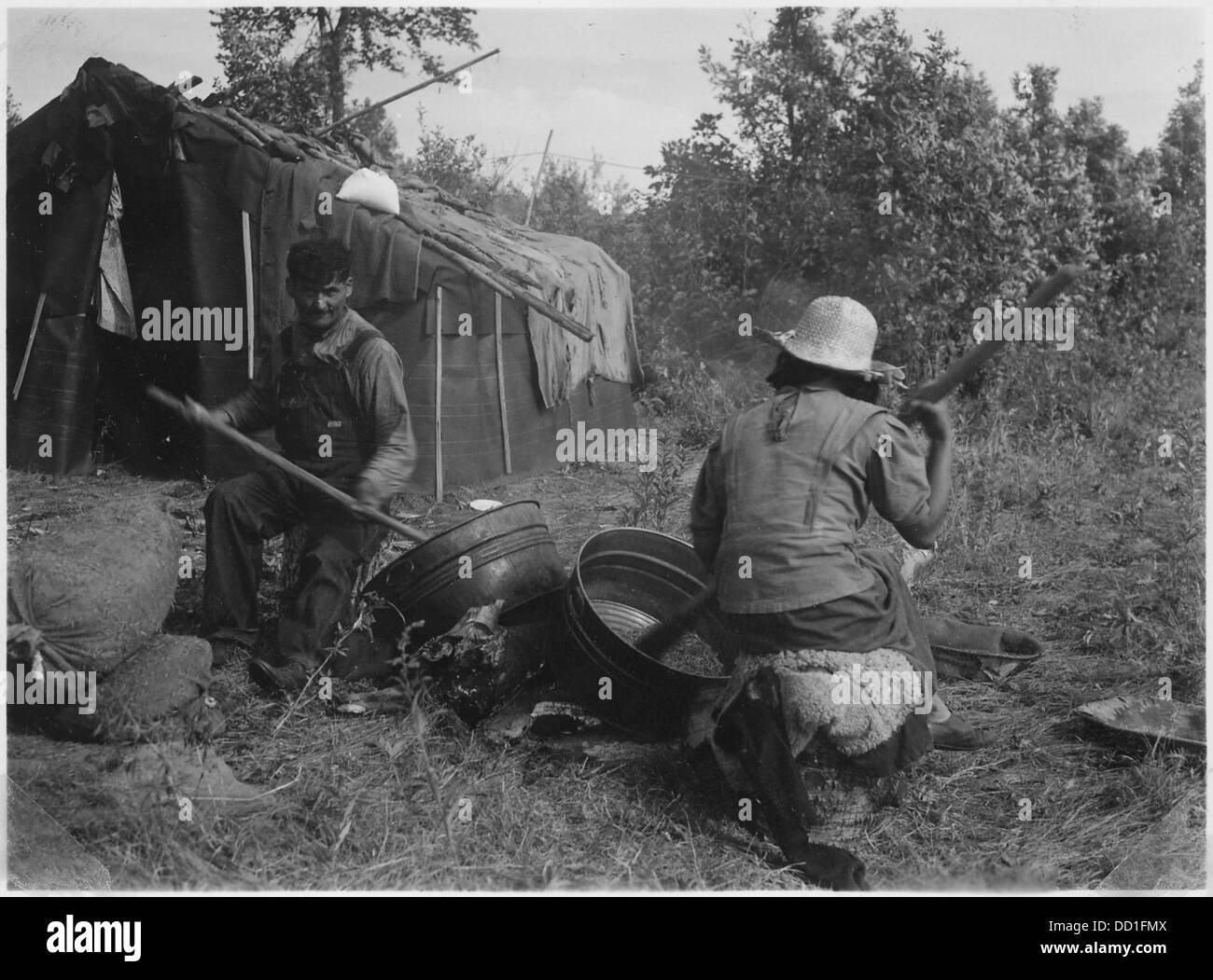 Paul Buffalo and his wife are shown parching wild rice at their camp, a ...