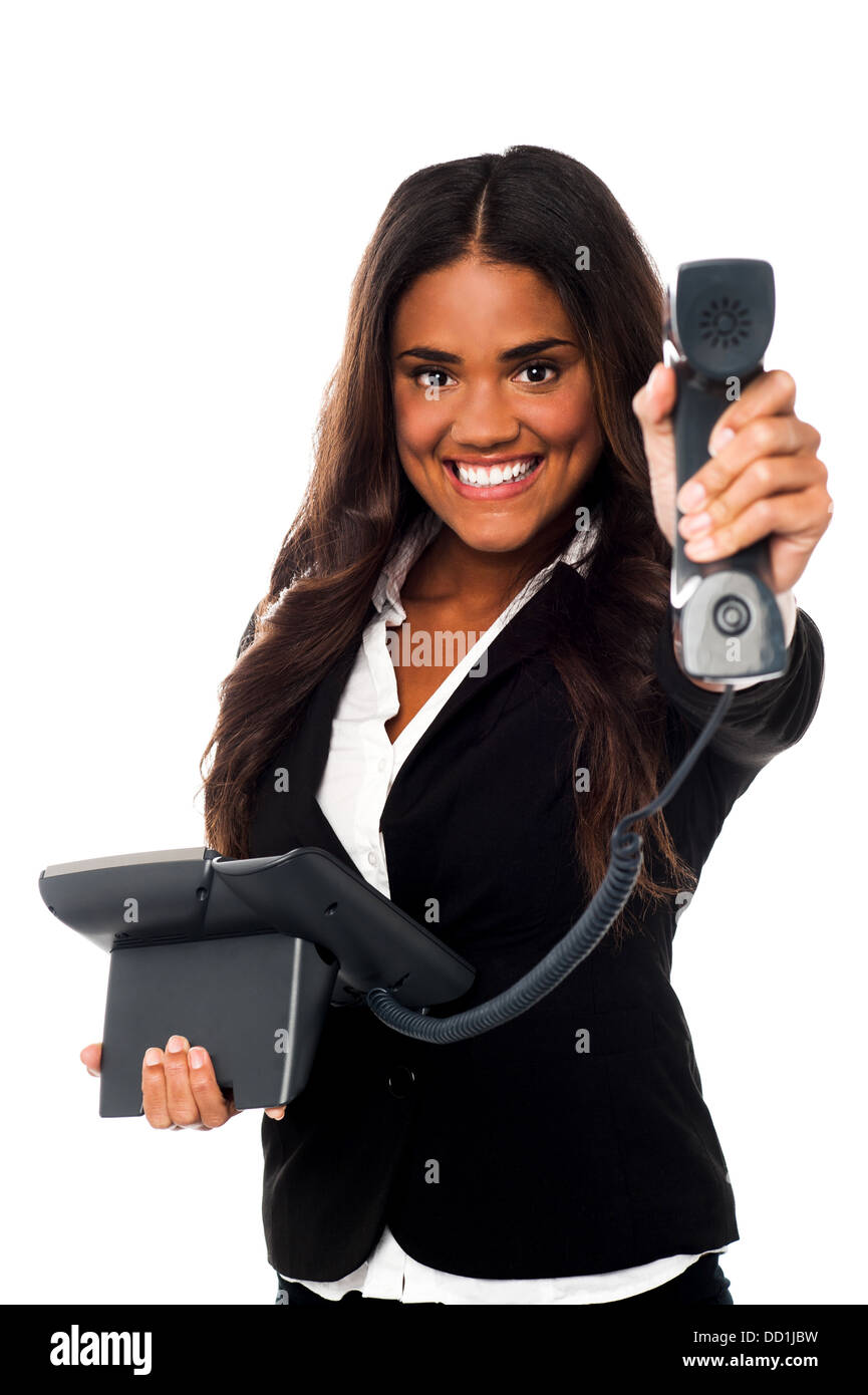 Smiling female assistant handing over the telephone receiver to her ...