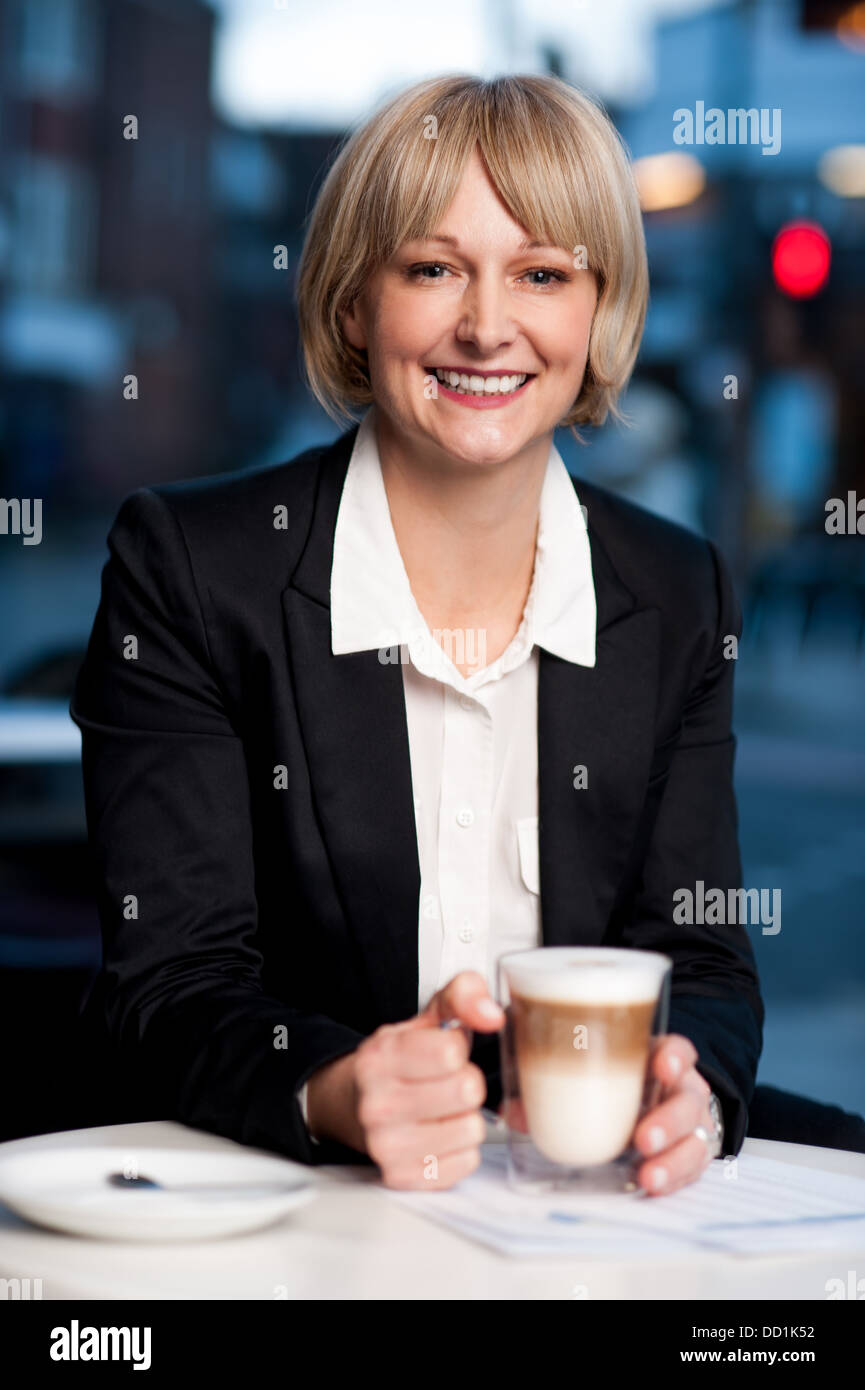 Confident smiling corporate lady holding coffee mug and posing Stock ...
