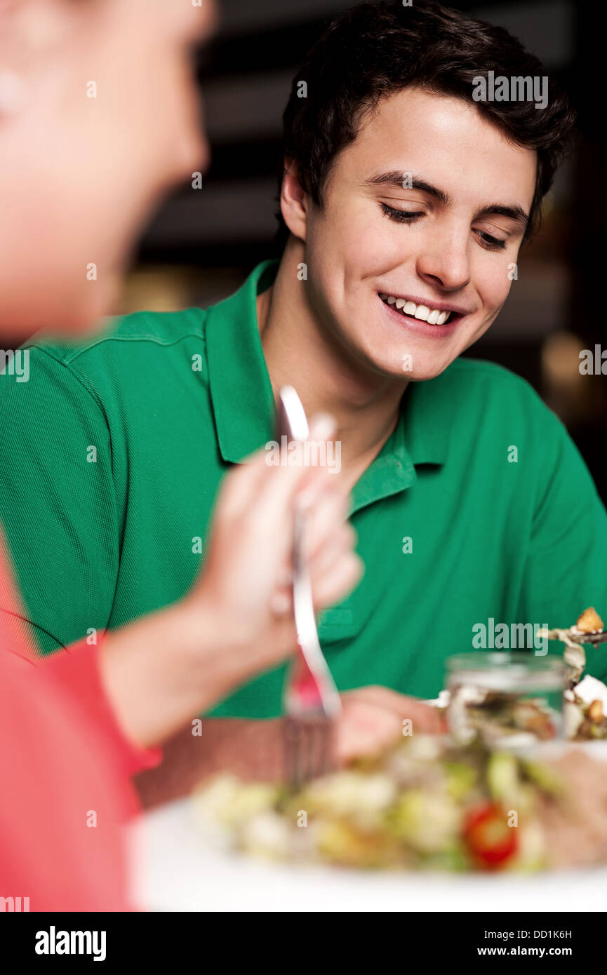 Boy in focus enjoying his meal. Having great time. Blur image of a ...