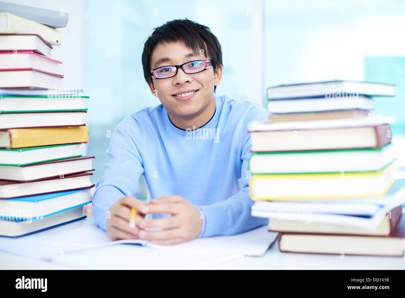 Portrait of successful Asian student sitting at workplace Stock Photo ...