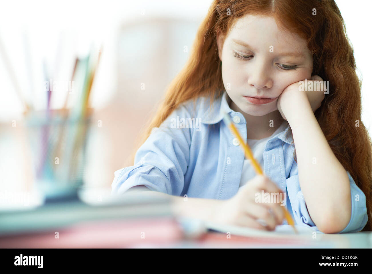 Cute little girl drawing with pencils at lesson Stock Photo - Alamy