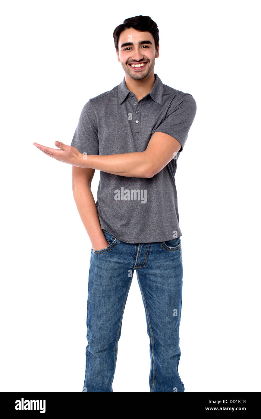 Smiling young casual guy presenting something Stock Photo - Alamy