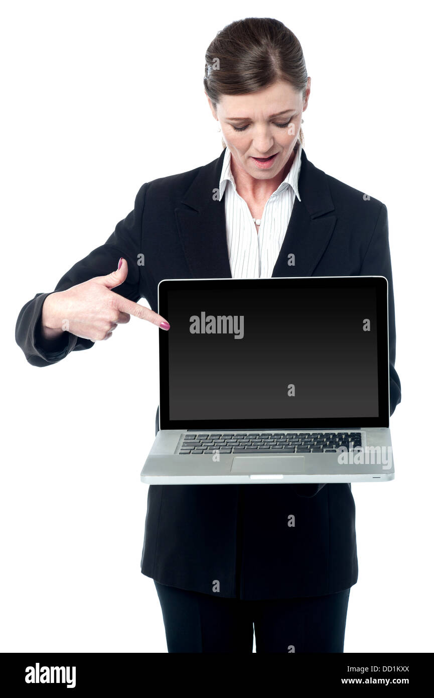Isolated corporate woman holding a laptop, pointing towards screen ...