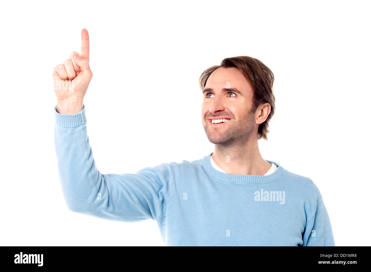 Smiling young man pointing upwards Stock Photo - Alamy