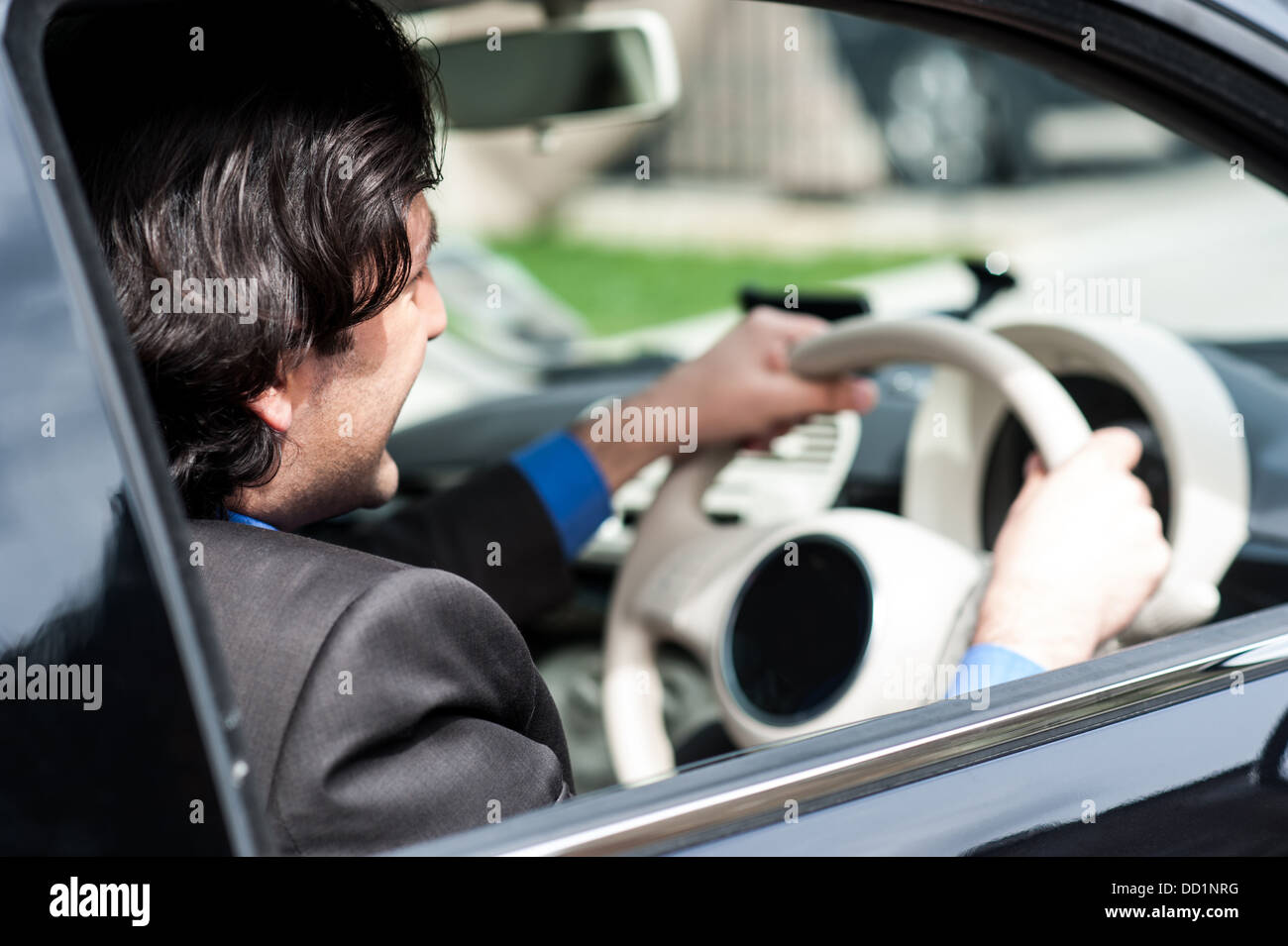 Corporate male driving car during day time Stock Photo - Alamy