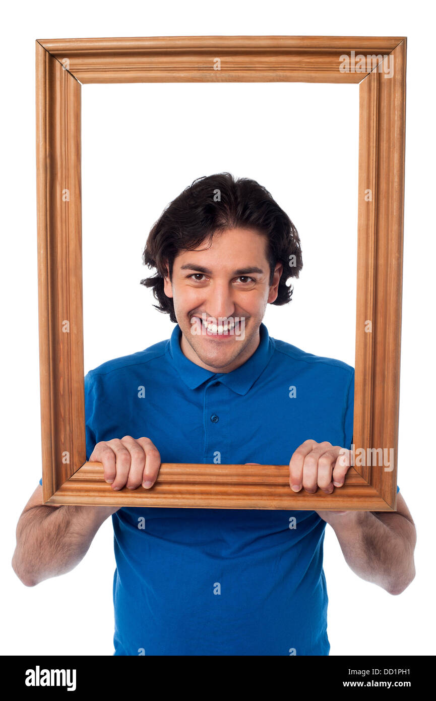Happy guy looking through empty picture frame Stock Photo - Alamy