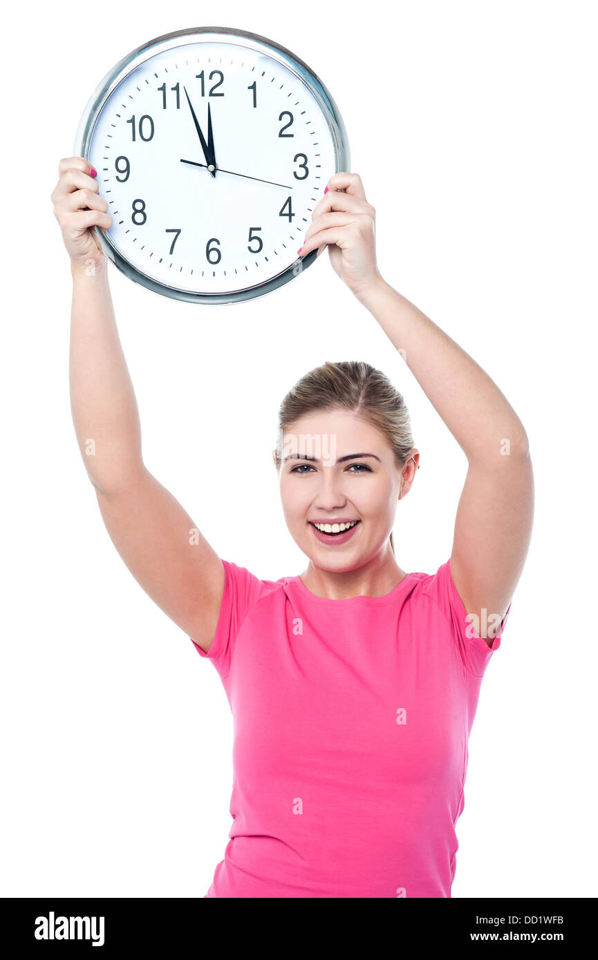 Beautiful young girl holding wall clock over her head Stock Photo - Alamy