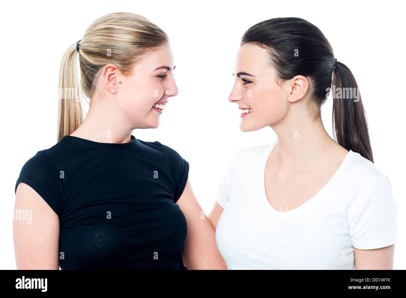 Beautiful young smiling girls facing each other Stock Photo - Alamy