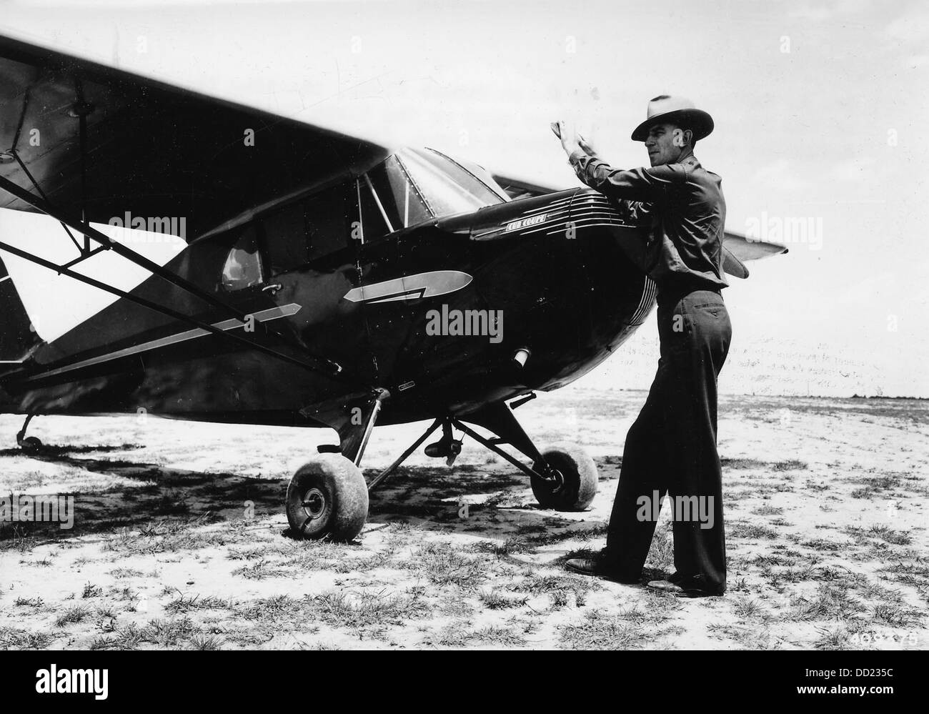 Lawrence Battey is seen starting the engine of a Piper Cub Coupe plane ...