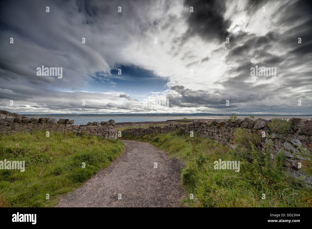 A Gravel Path Leading To The Ocean With Stone Walls On Holy Island ...