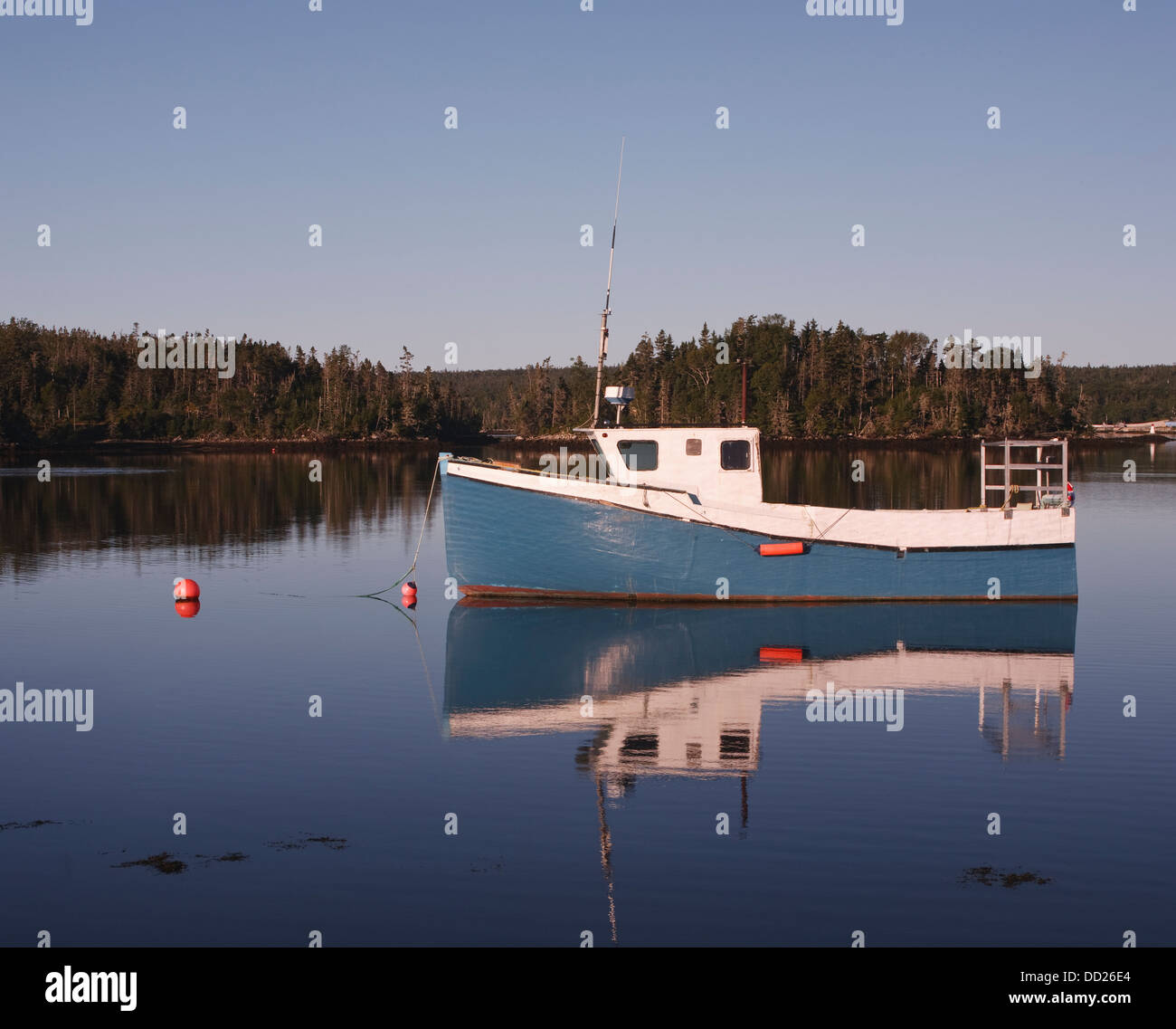 Small fishing boat anchored on a calm morning Stock Photo - Alamy