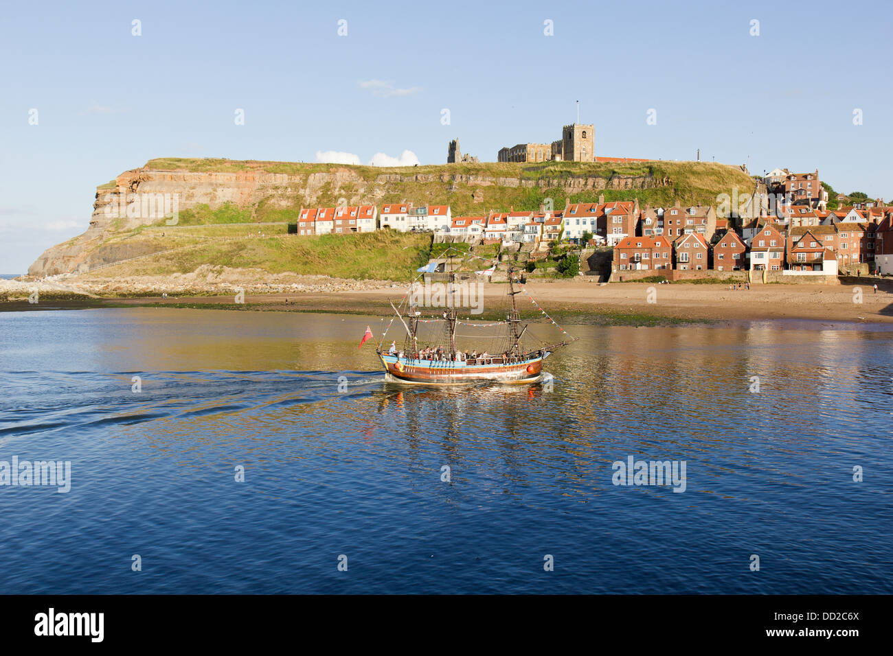 Whitby harbour with the sailing replica ship Endeavour and the abbey ...