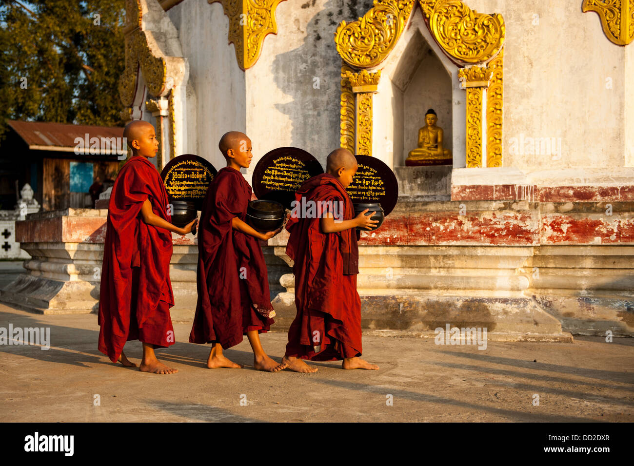 Three young monks walking past temple in Burma Myanmar Stock Photo - Alamy