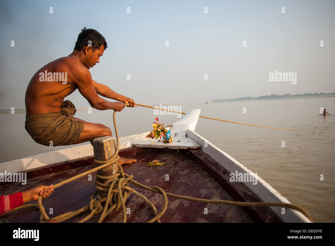 crew member freeing boat from sandbar on Chin Win River Burma/ Myanmar ...