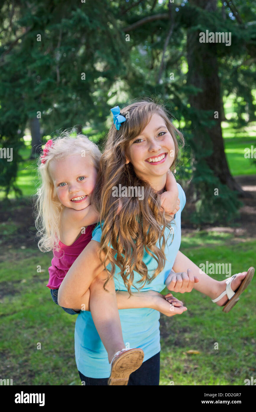Two Sisters Playing Together In The Park; Edmonton, Alberta, Canada ...