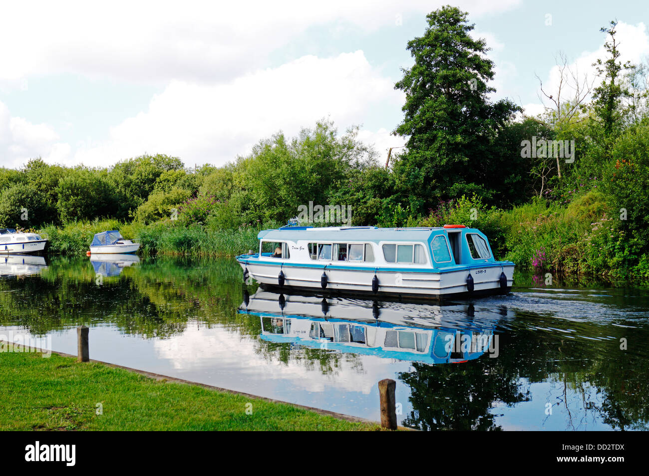 A cruiser on the River Bure on the Norfolk Broads at Belaugh, near ...