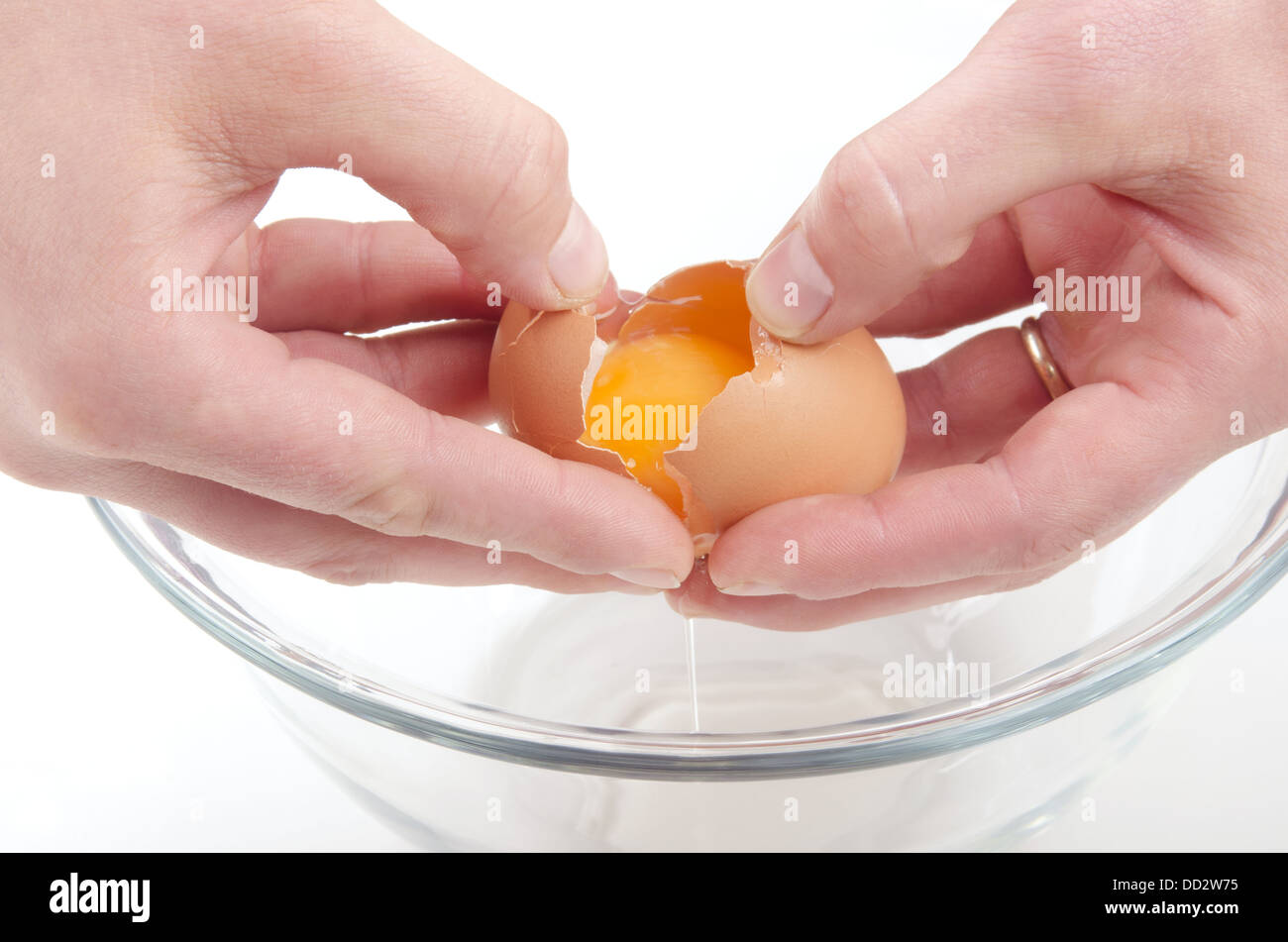 one open egg over a glass bowl Stock Photo - Alamy