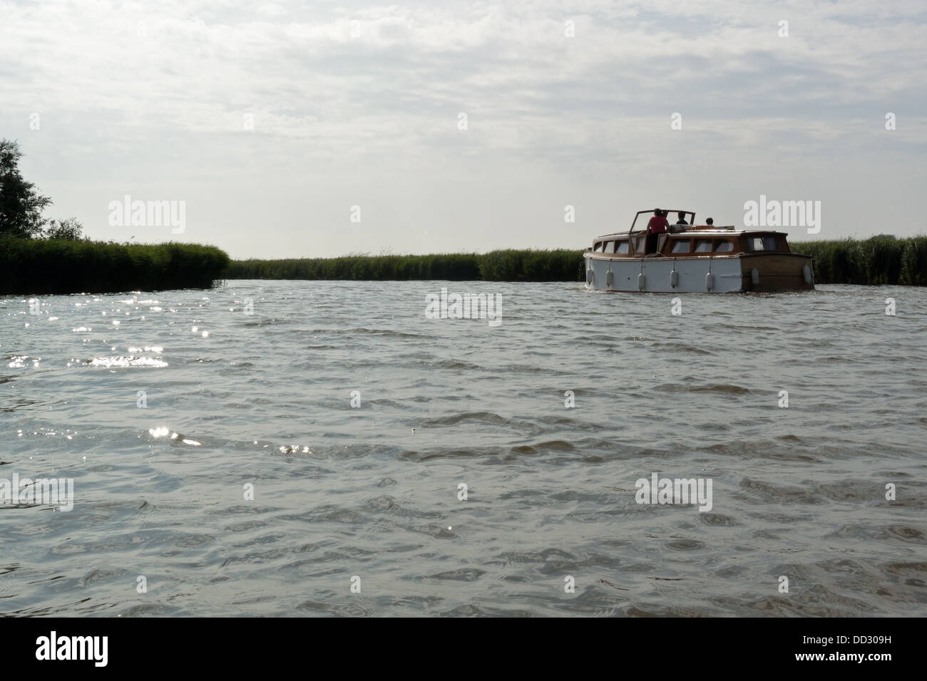 Traditional wooden Broads cruiser about to enter Meadow Dyke from ...