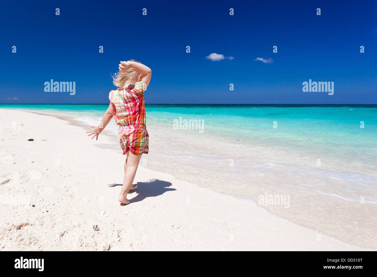 Happy little girl having fun on the beach Stock Photo - Alamy