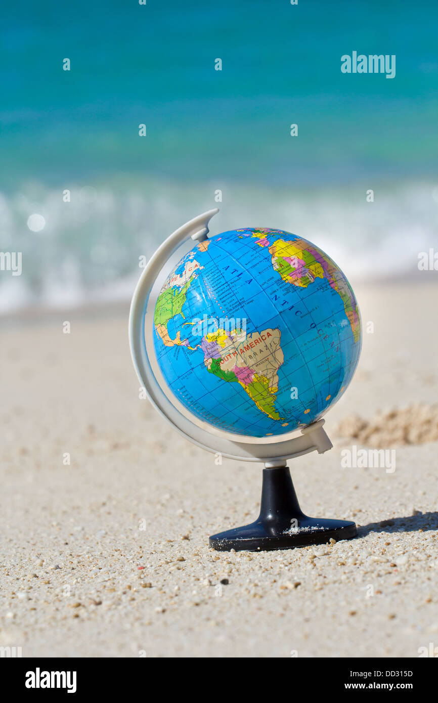 Globe on caribbean beach, travel concept Stock Photo - Alamy